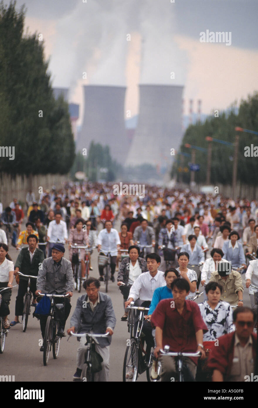 Workers cycling home from work at Bautou Steel factory Inner Mongolia ...