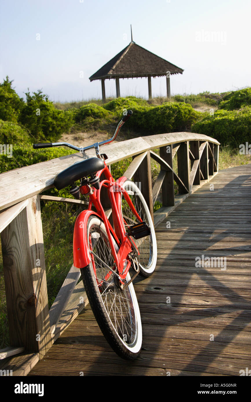 Image of red bike leaned up against railing of boardwalk Stock Photo ...