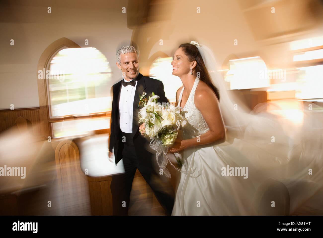 Bride and groom leaving church with motion blur effect Stock Photo - Alamy