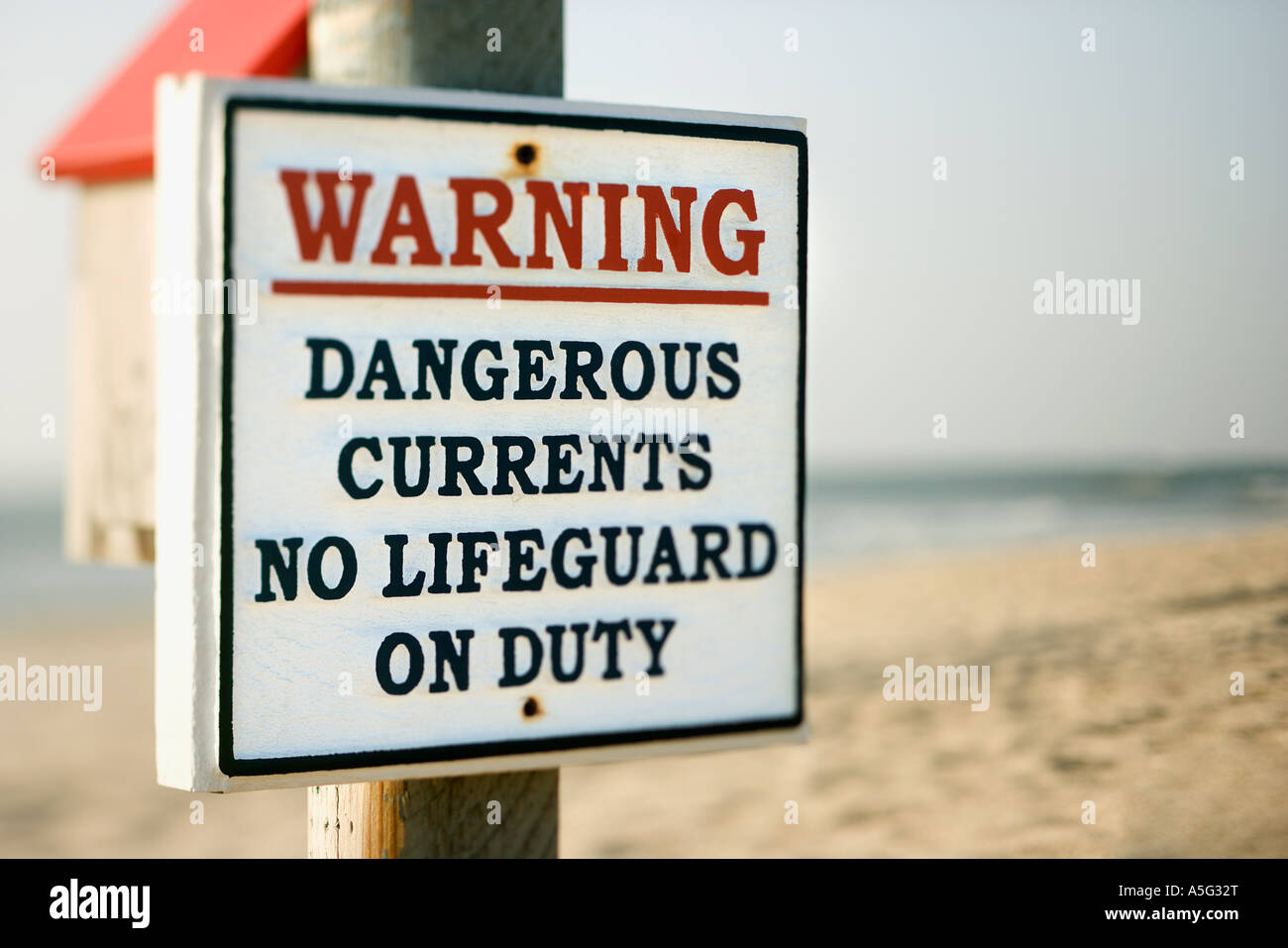 Warning sign on post at the beach with ocean in background Stock Photo ...