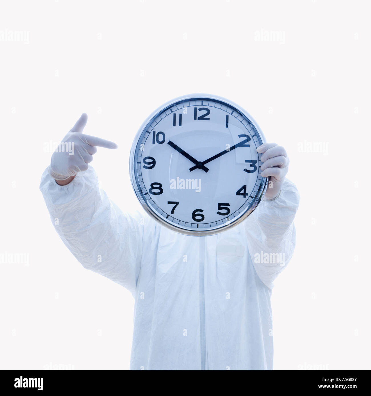 Man in biohazard suit holding clock in front of face pointing to clock ...