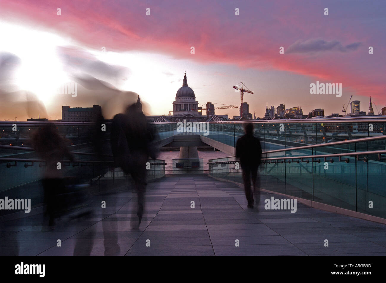 People walking over Millennium Bridge London at dusk Stock Photo - Alamy