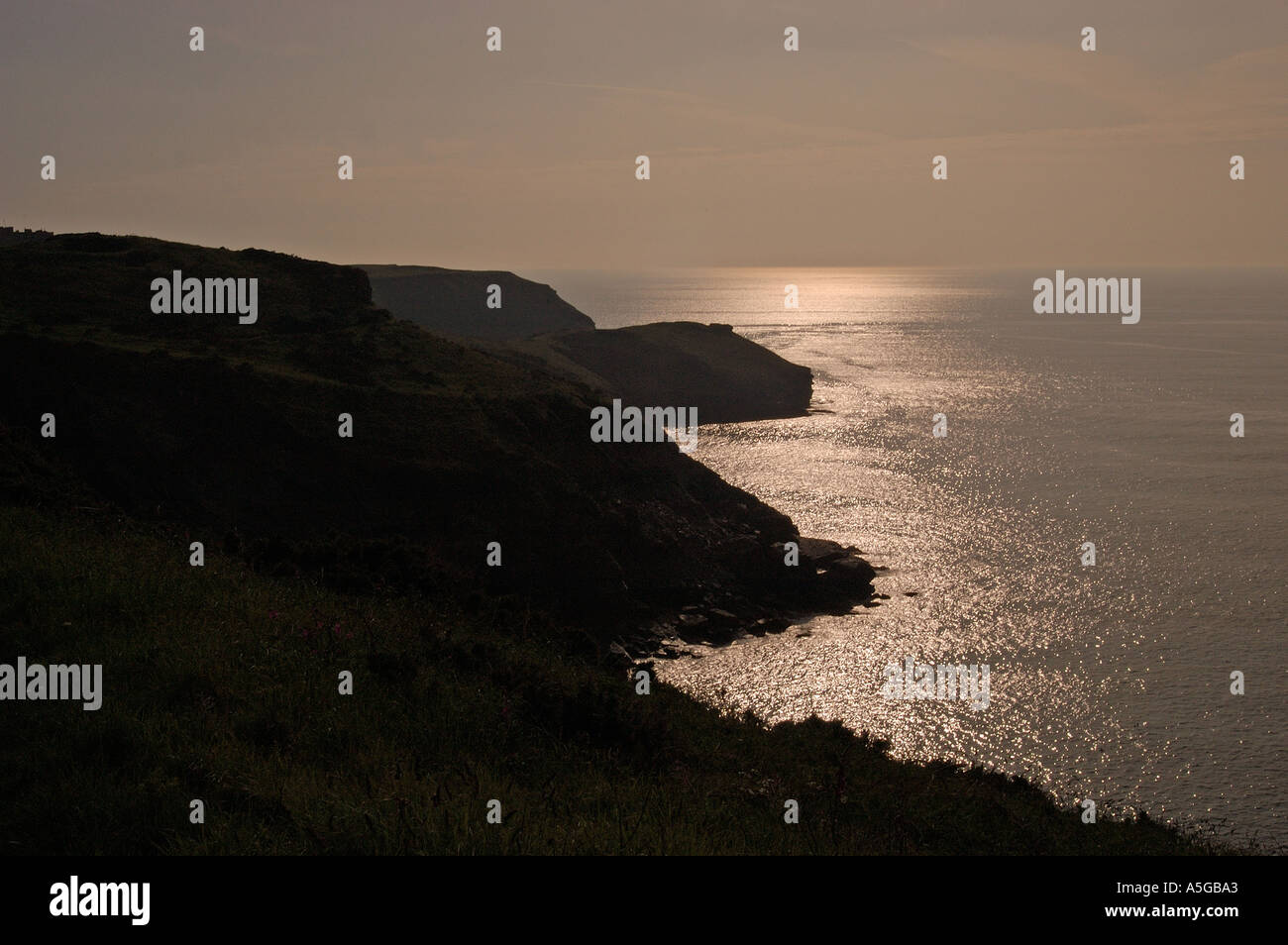 Silhouetted Cornish coastline in evening sun Stock Photo - Alamy