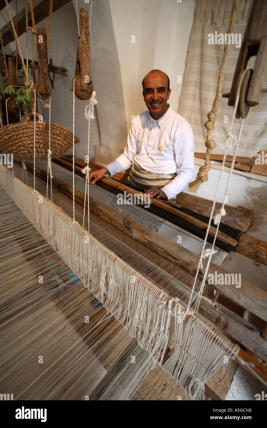 Vertical portrait of weaver and his loom in berber village museum ...
