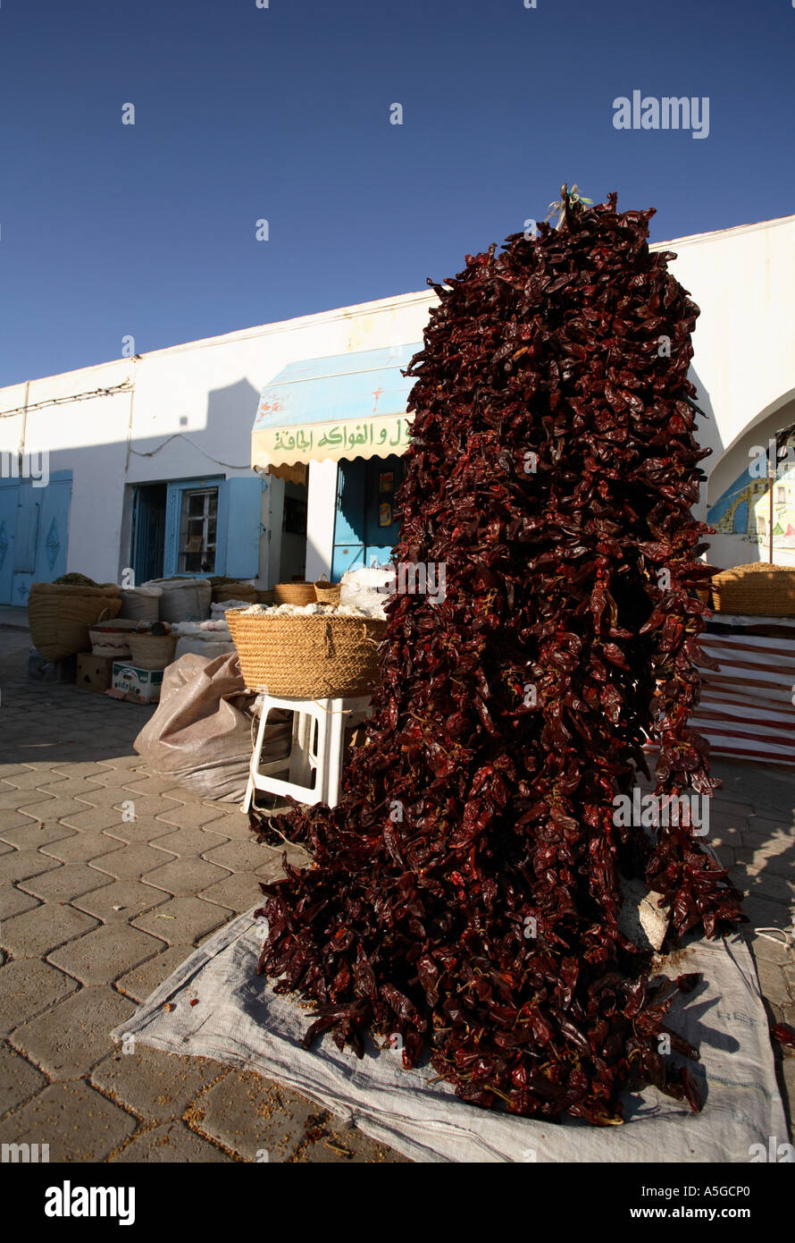 Vertical landscape detail of ropes of dried chilli peppers hanging in ...