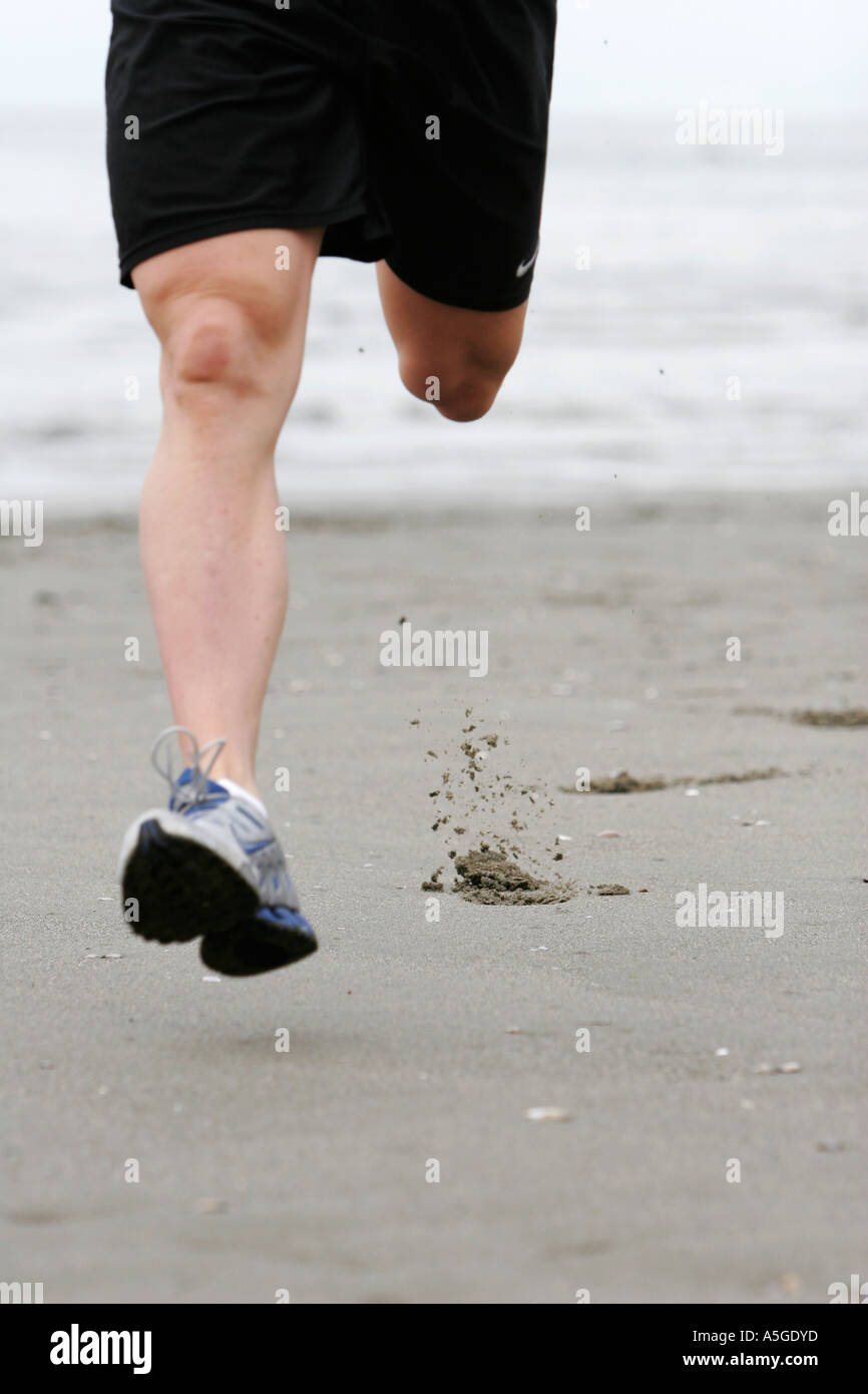 fit male model running outside beach water ocean Stock Photo - Alamy