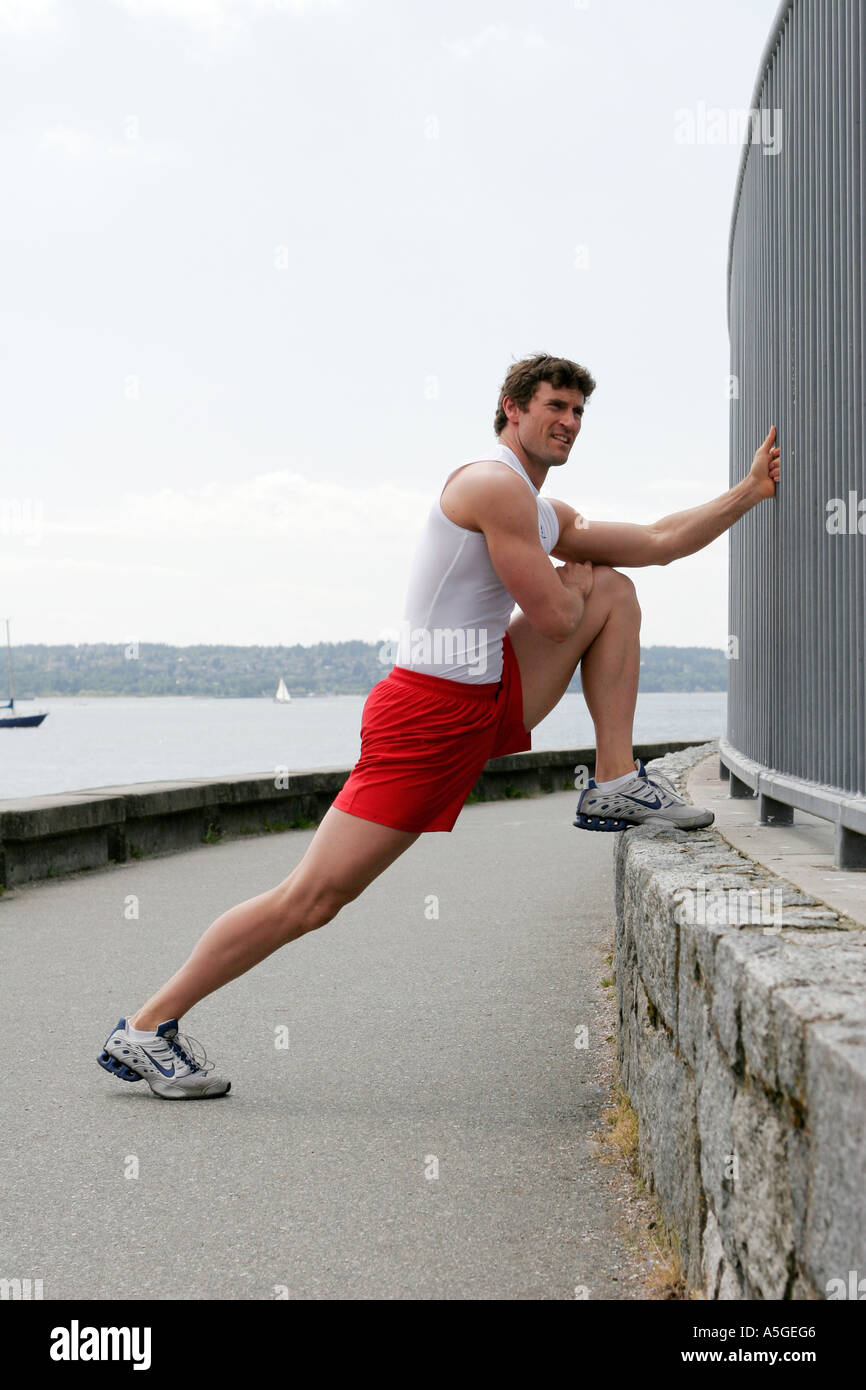 fit male model running outside beach water ocean Stock Photo - Alamy