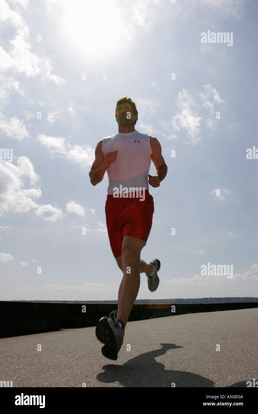 fit male model running outside beach water ocean Stock Photo - Alamy