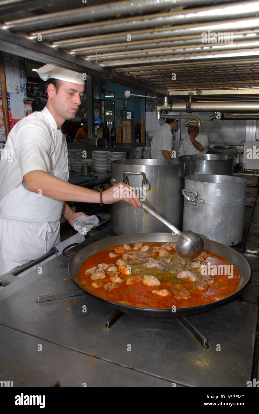 A chef cooking a Valencian paella in the kitchen at La Pepica ...