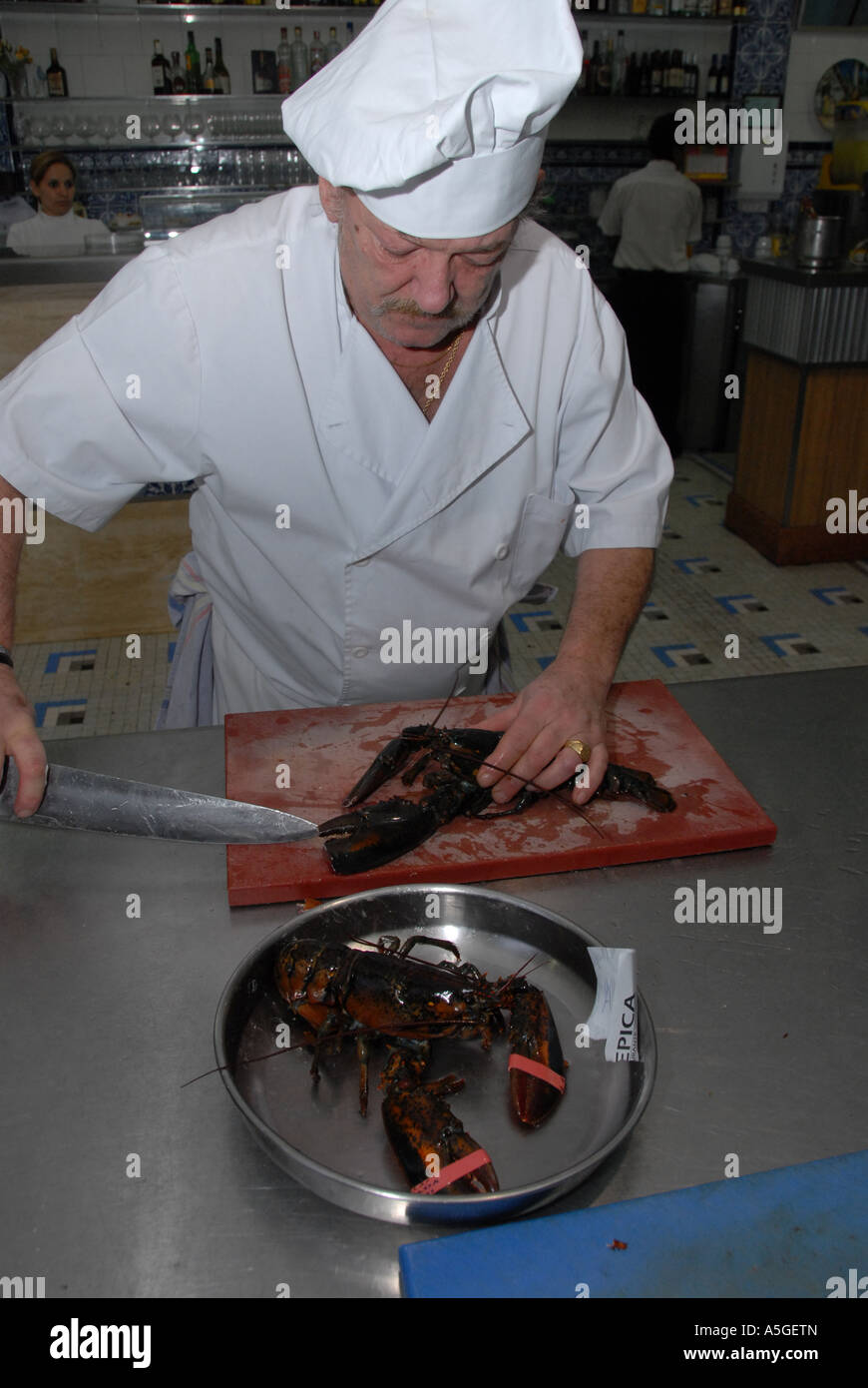 Head chef prepares two live lobsters for a lobster paella in the ...
