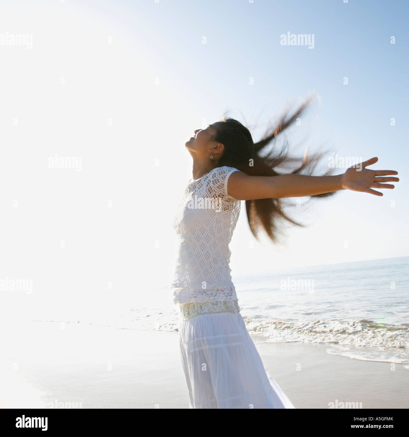 Young Asian female at beach throwing her arms back behind her Stock ...