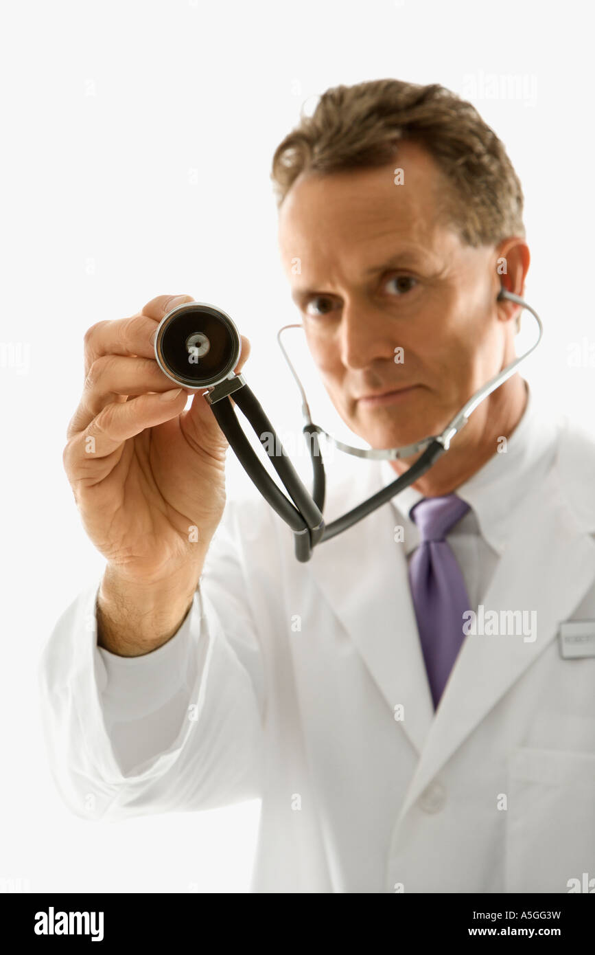 Studio shot of a mid adult Caucasian male doctor holding out ...