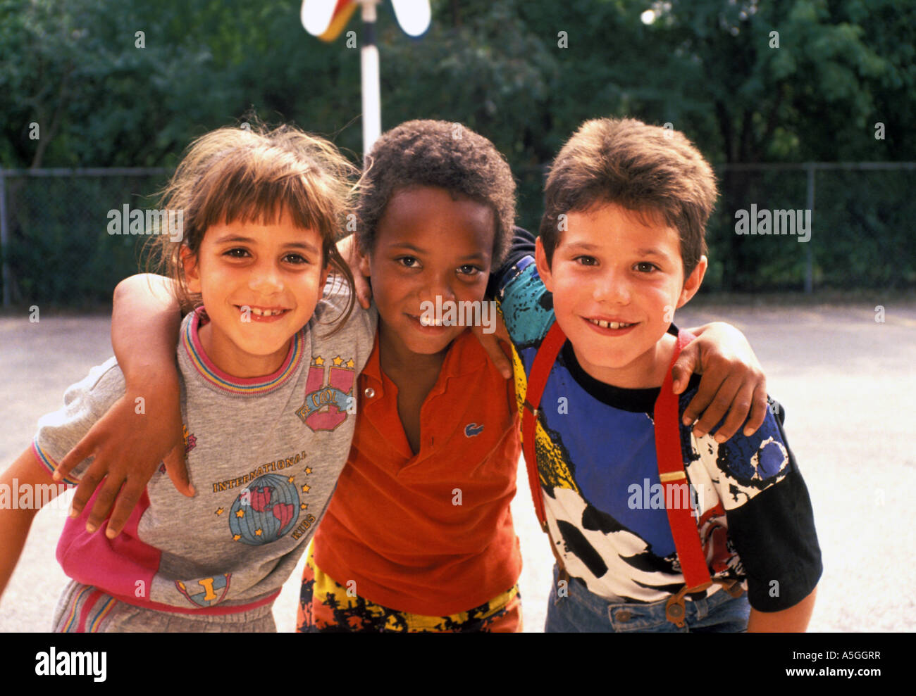 portrait of three children of different nationalities embracing each ...