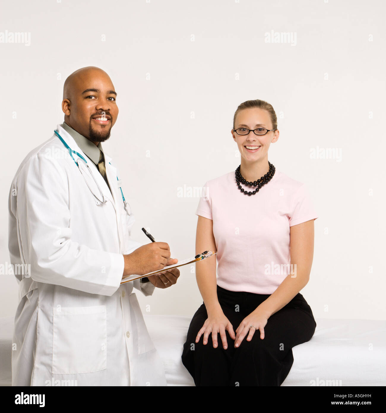 Doctor and patient looking at viewer smiling Stock Photo - Alamy
