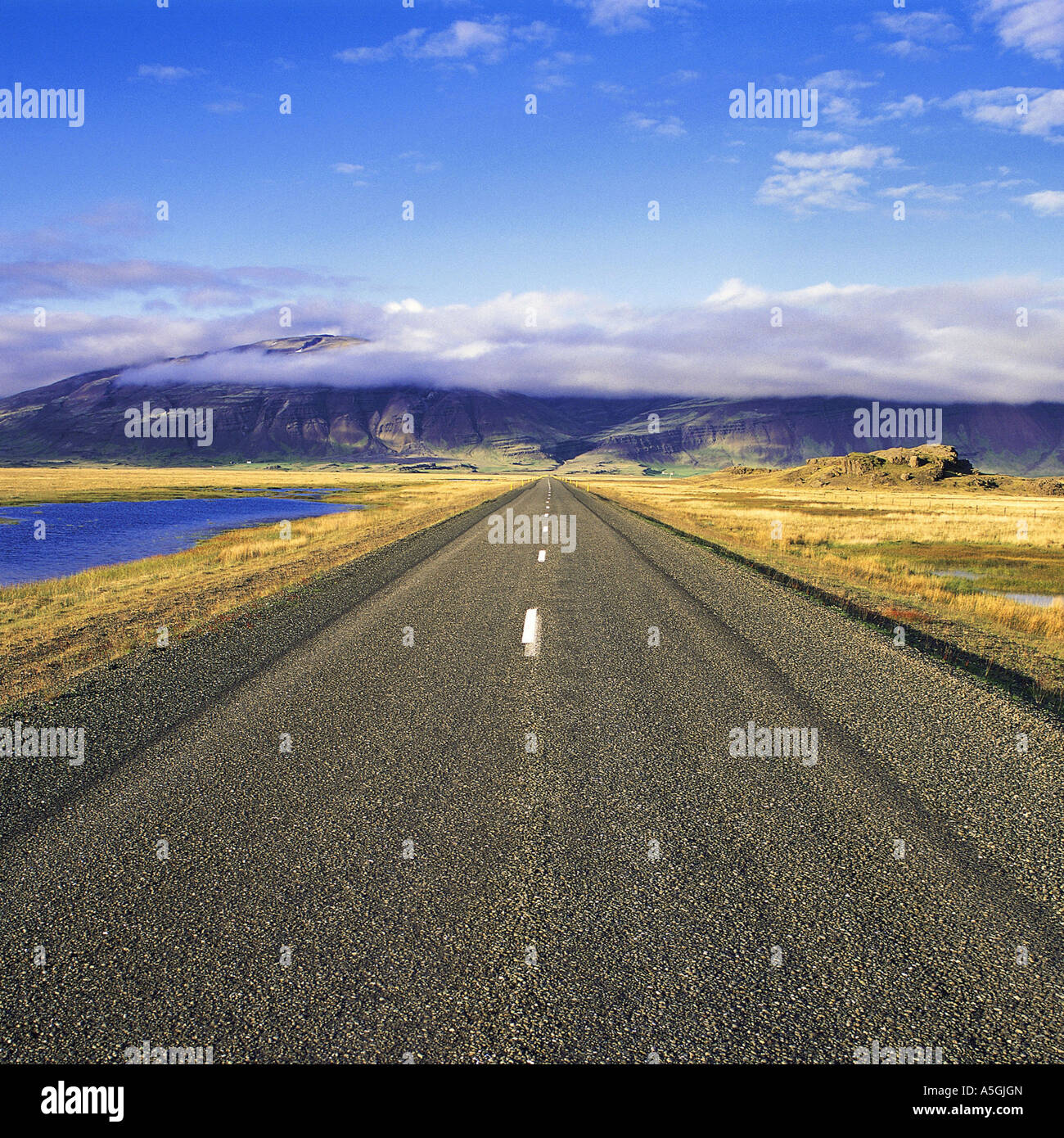 Long straight road with misty hills in the distance, Iceland Stock ...