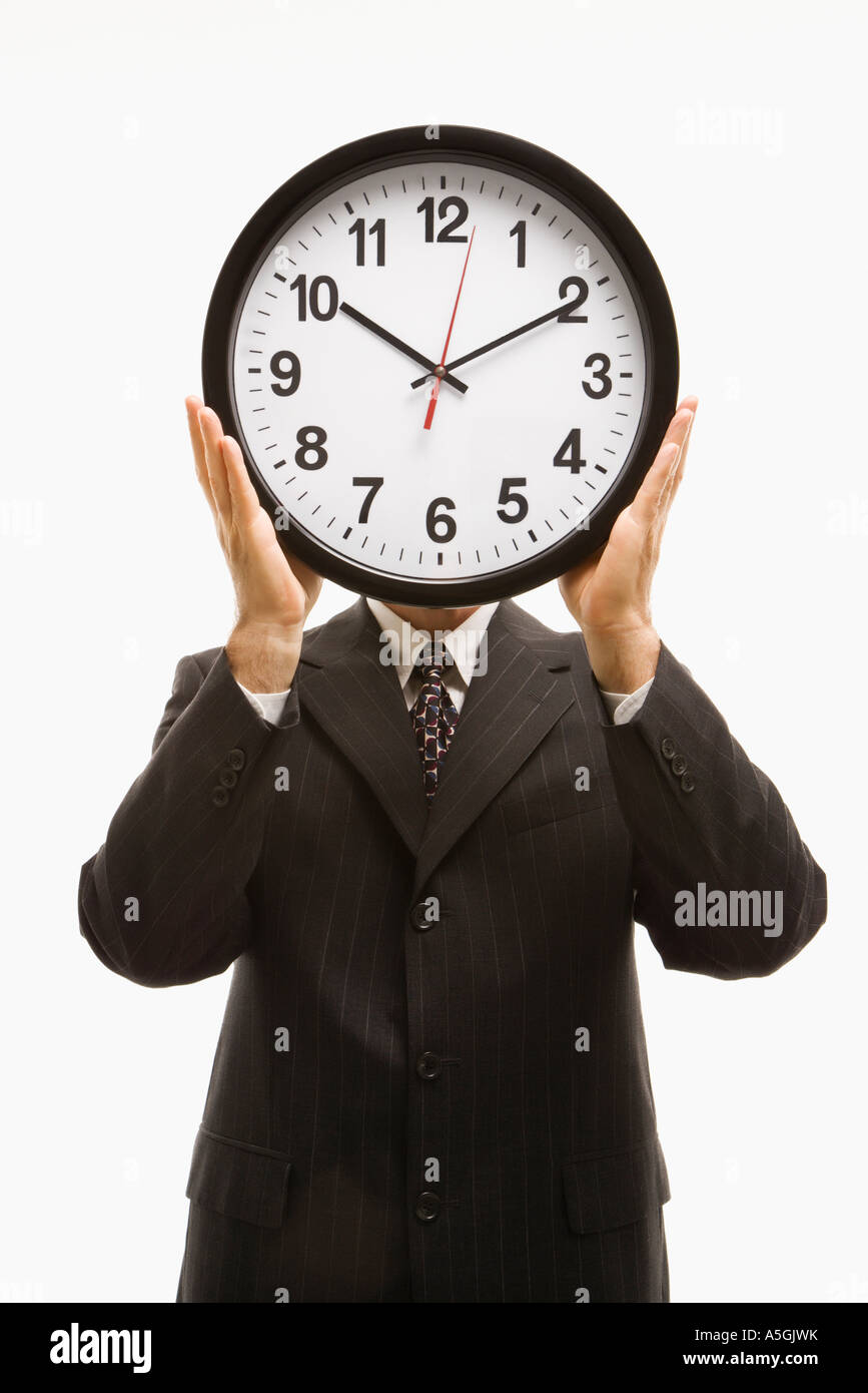 Caucasian middle aged businessman holding clocks in front of their ...