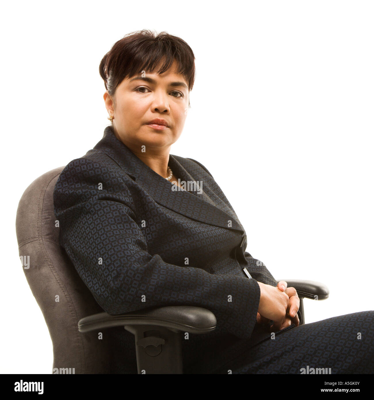 Filipino middle aged businesswoman sitting in office chair against ...