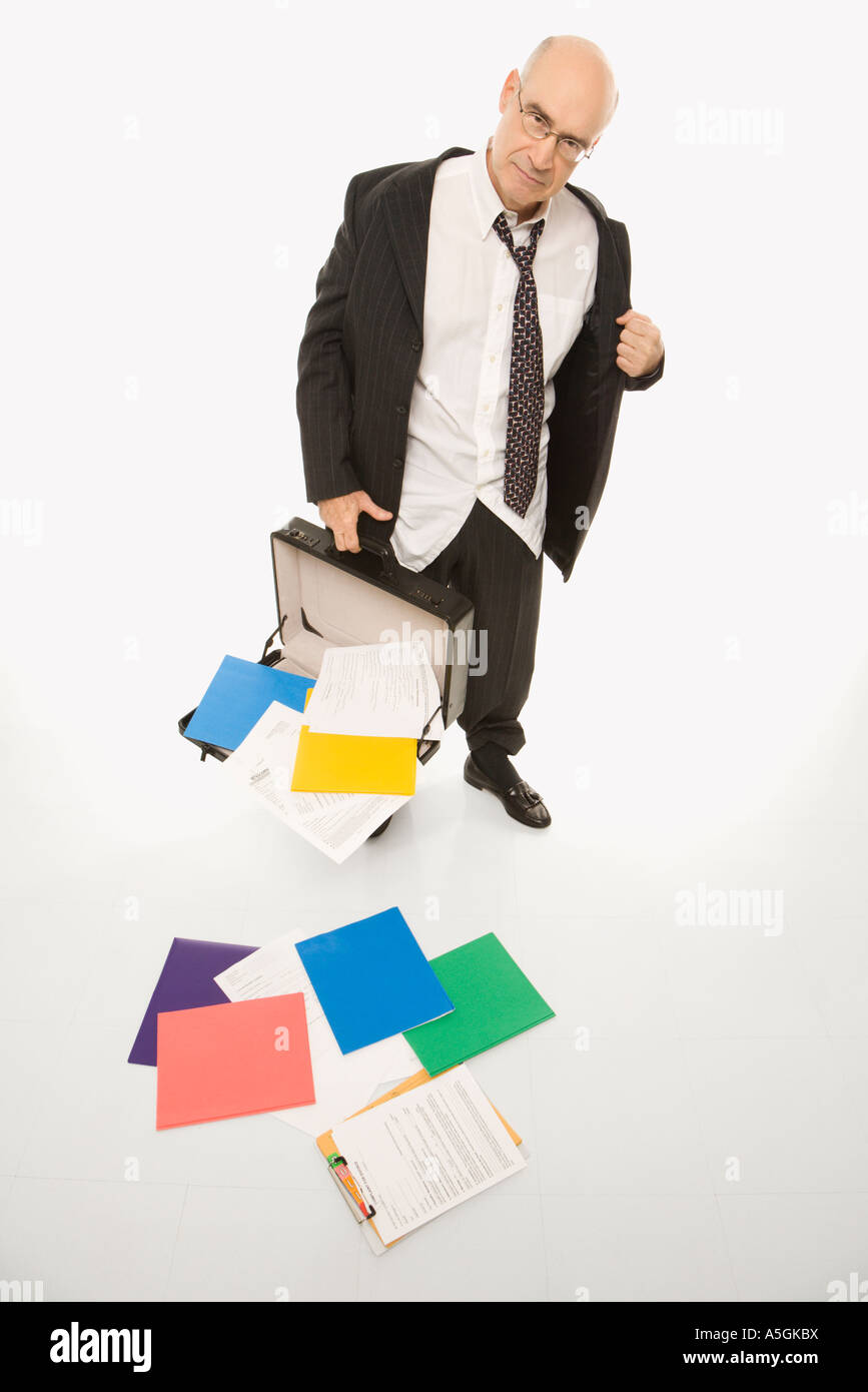 Businessman looking disheveled holding open briefcase with papers ...