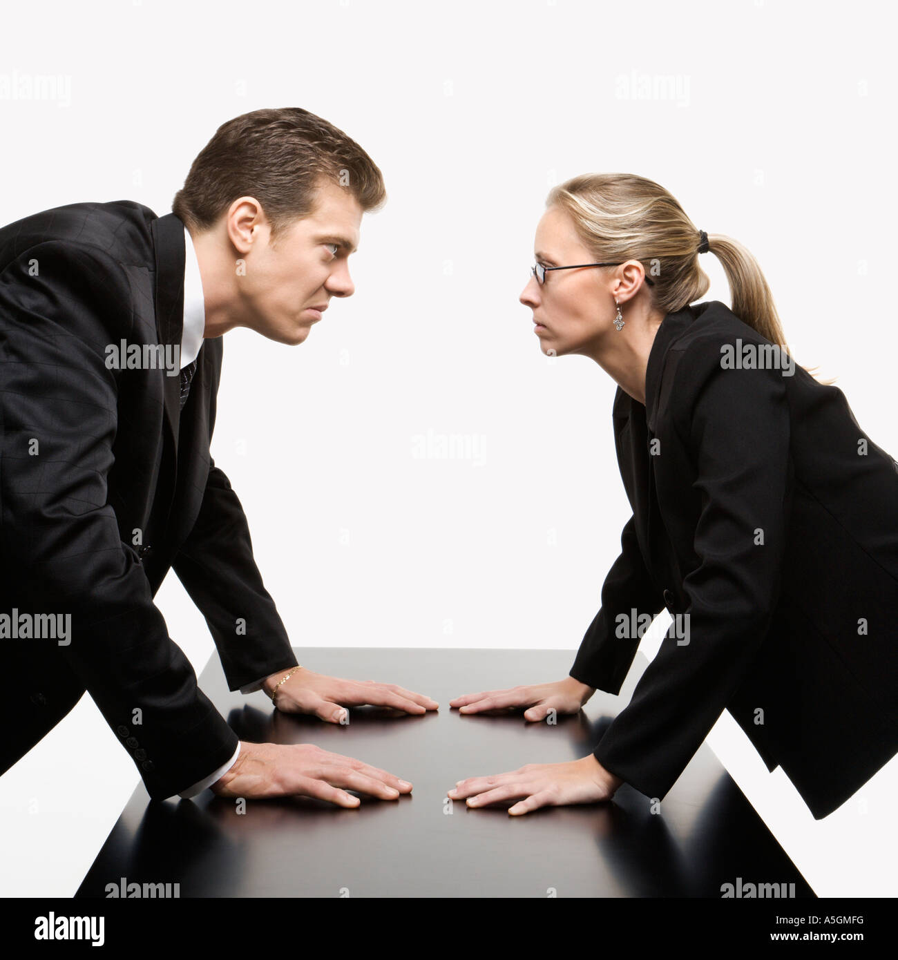 Caucasian mid adult businessman and woman staring at each other with ...