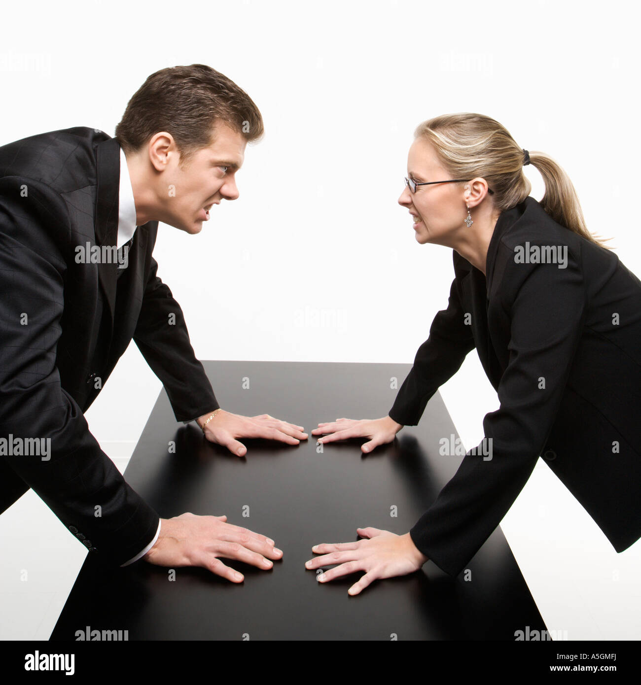 Caucasian mid adult businessman and woman staring at each other with ...