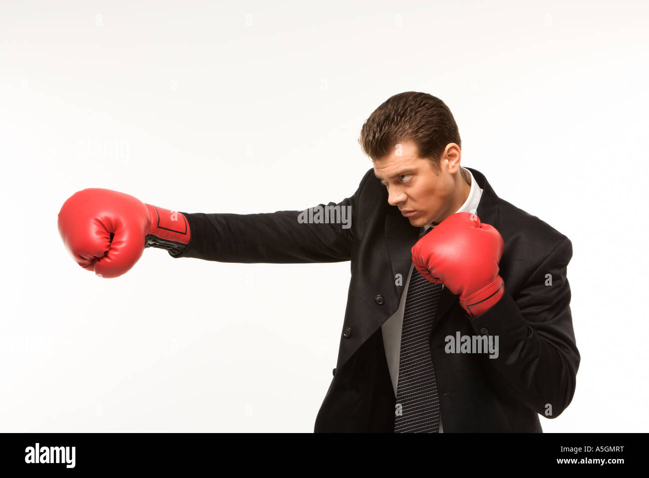Caucasian mid adult man wearing suit and punching with boxing gloves ...
