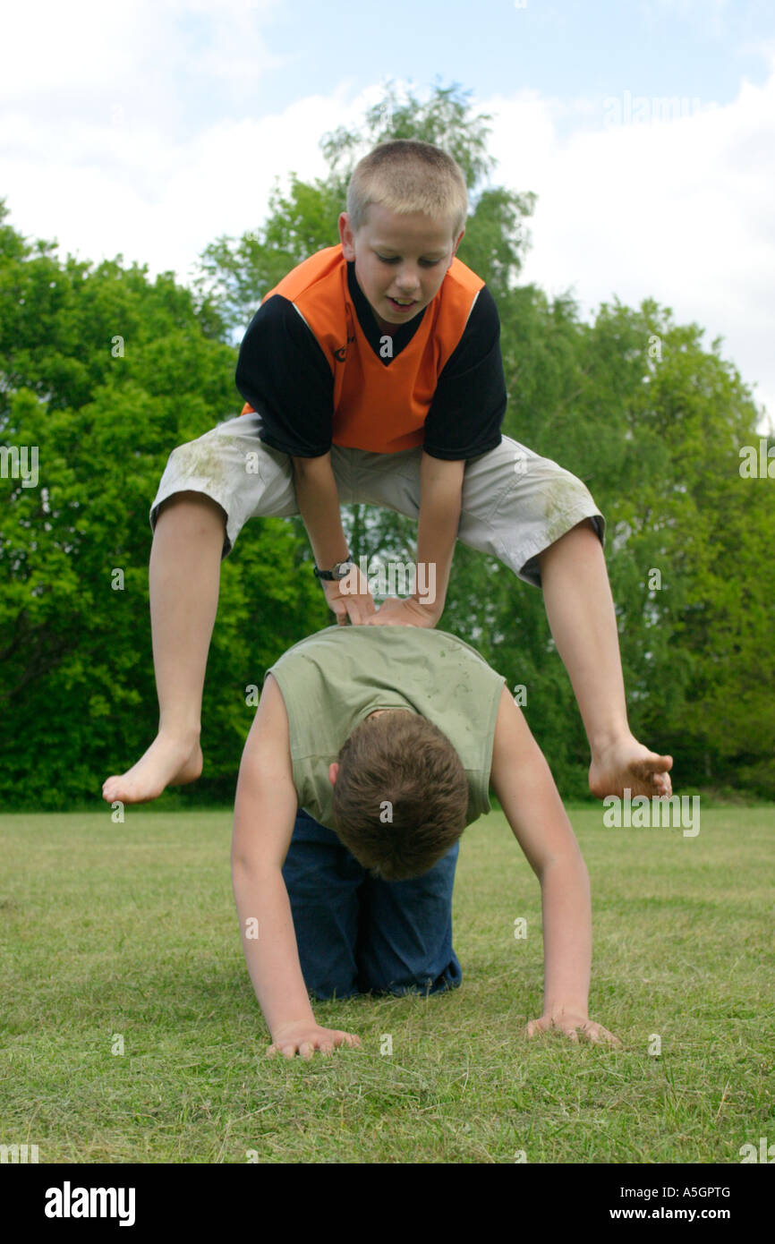 two young boys playing leapfrog Stock Photo - Alamy