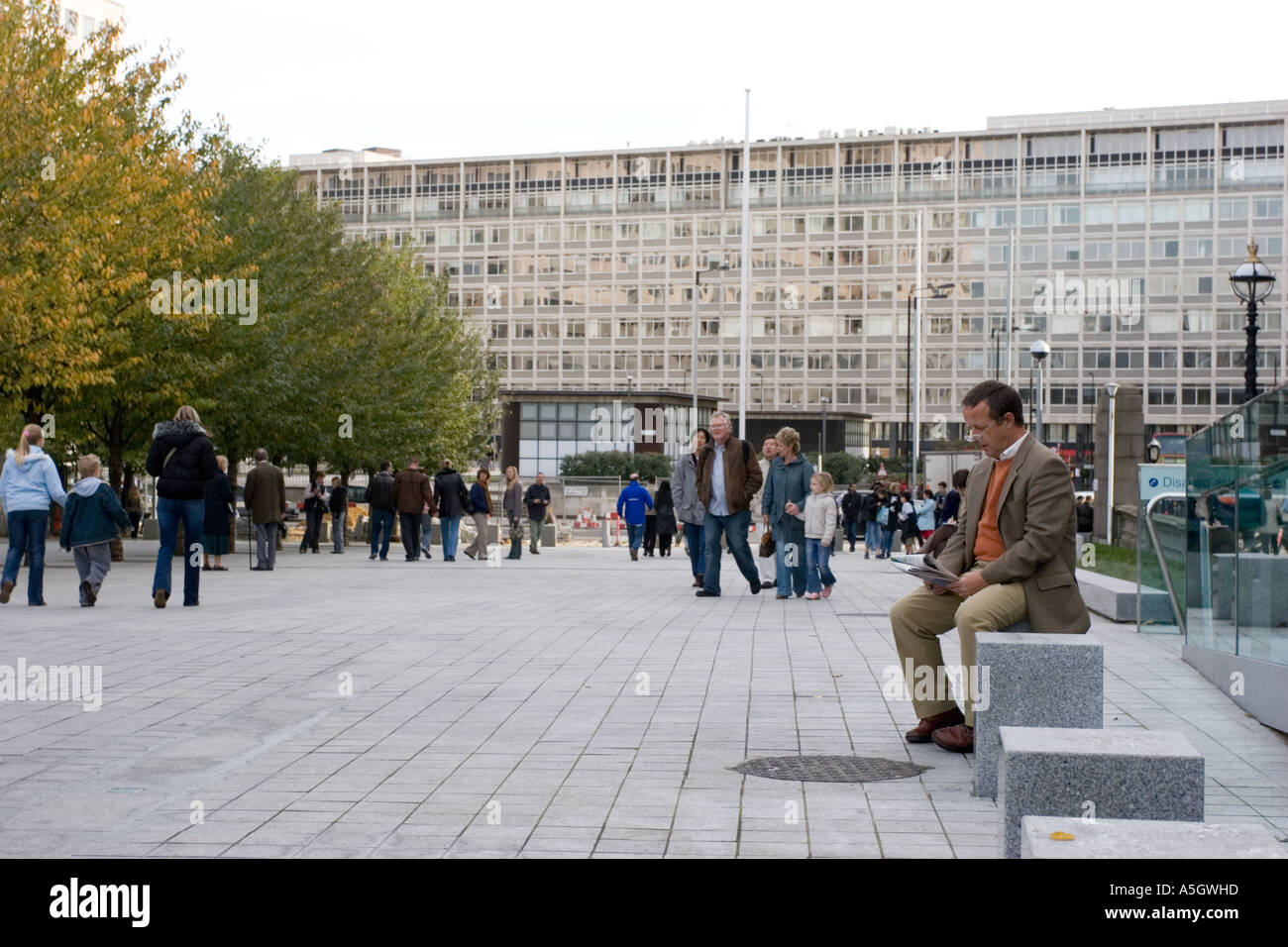 Gentleman reading a book in crowded precinct Stock Photo - Alamy