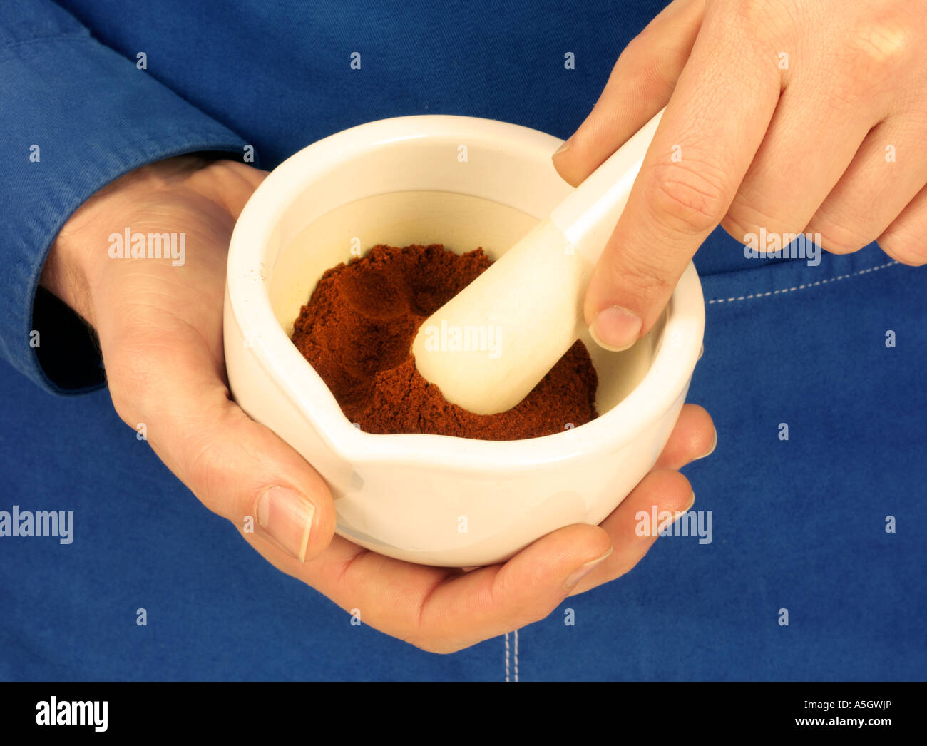 MAN GRINDING CHILLI POWDER Stock Photo - Alamy