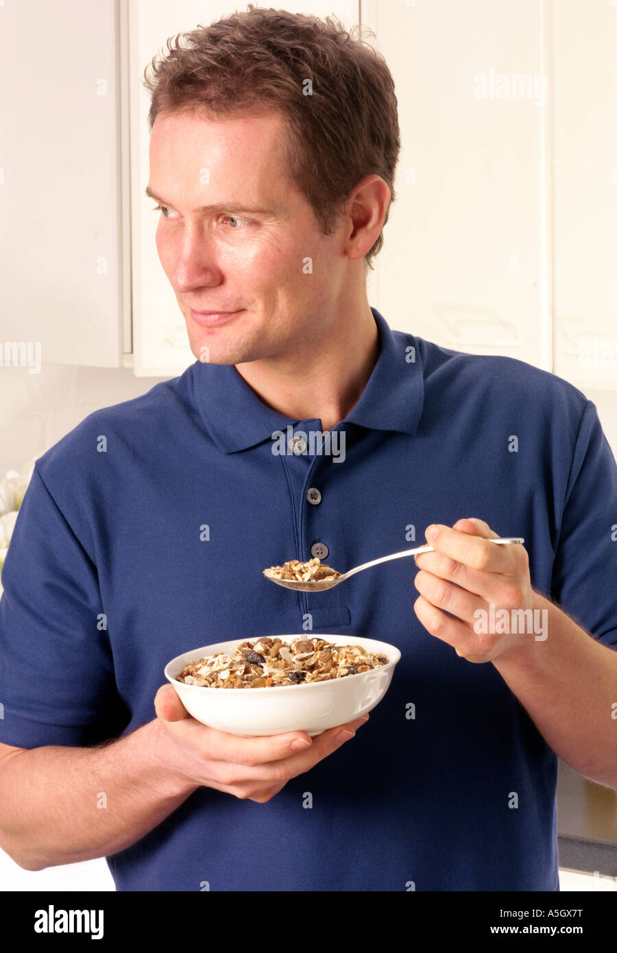 MAN IN KITCHEN EATING MUESLI Stock Photo - Alamy