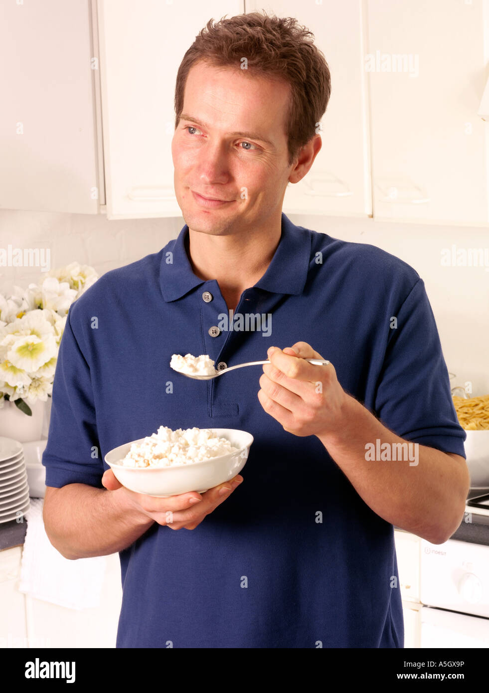 MAN IN KITCHEN EATING COTTAGE CHEESE Stock Photo - Alamy