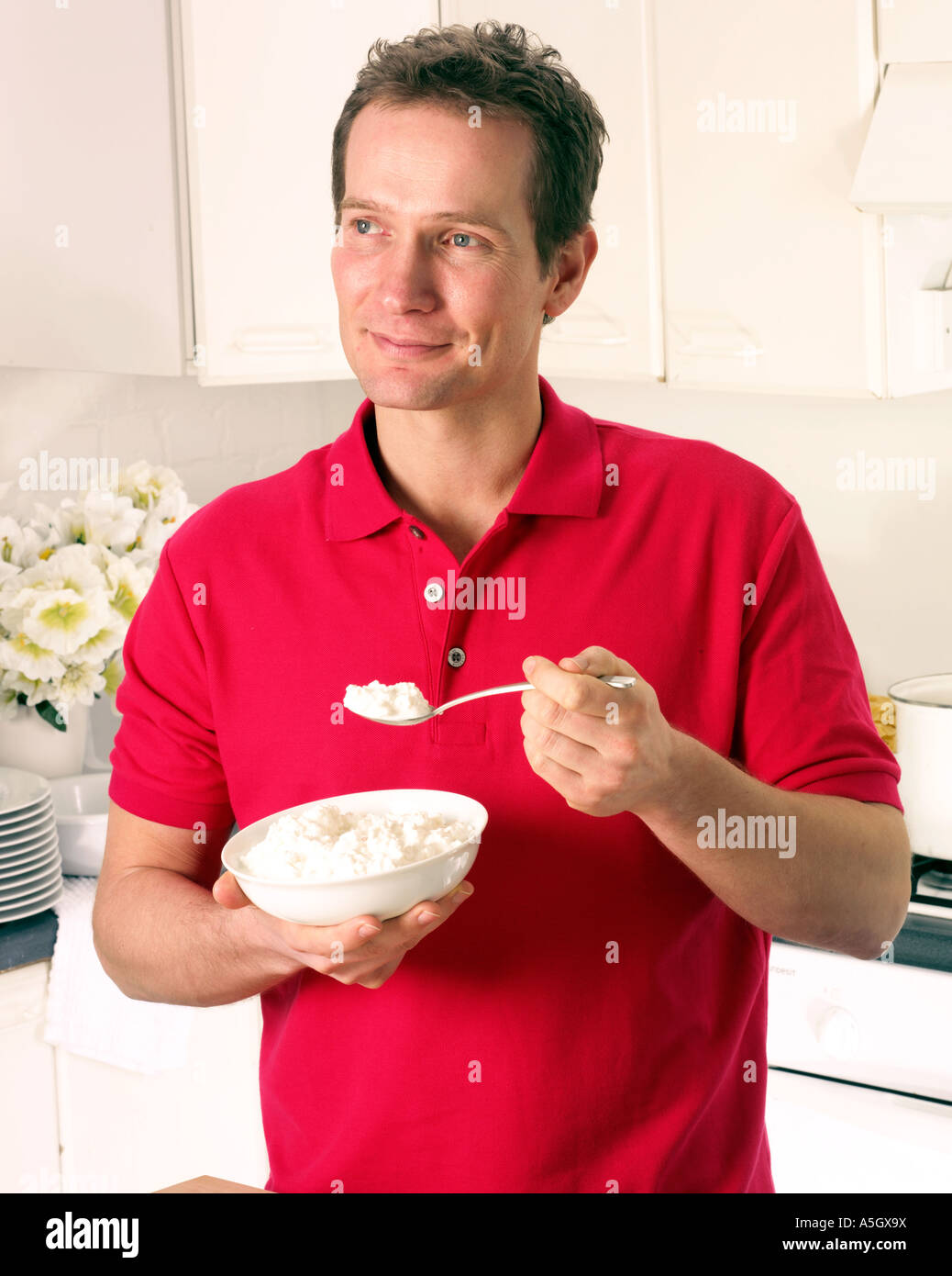MAN IN KITCHEN EATING COTTAGE CHEESE Stock Photo - Alamy