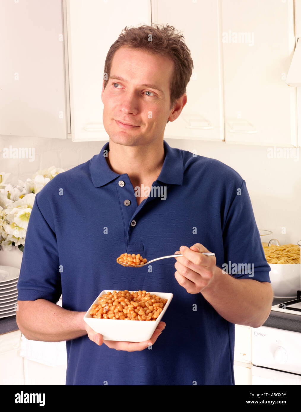 MAN IN KITCHEN EATING BAKED BEANS Stock Photo - Alamy