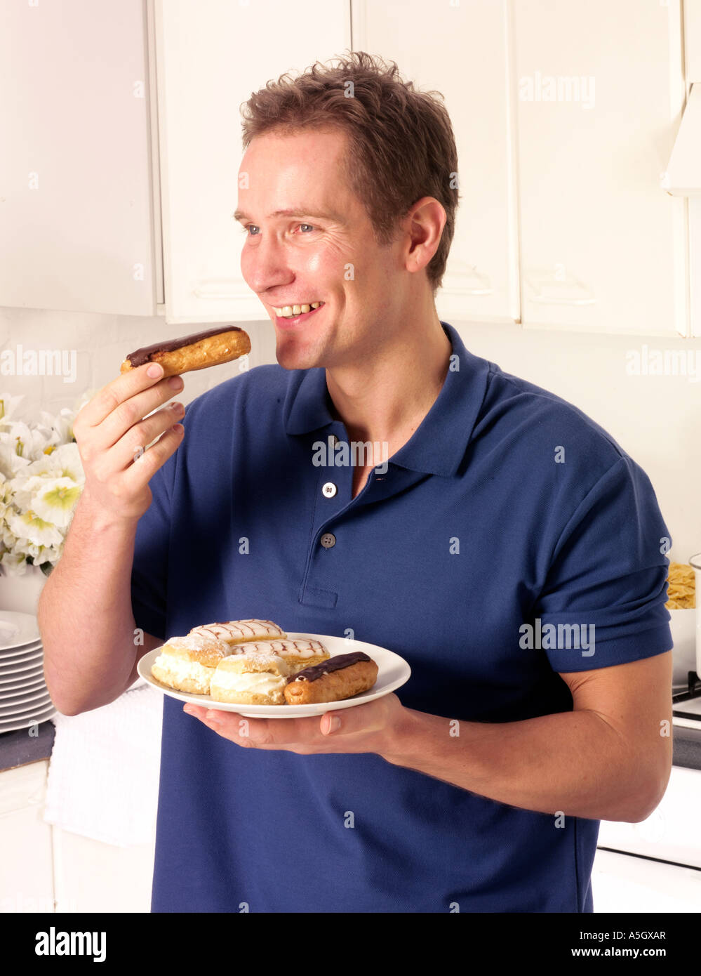 MAN IN KITCHEN EATING CREAM CAKES Stock Photo - Alamy