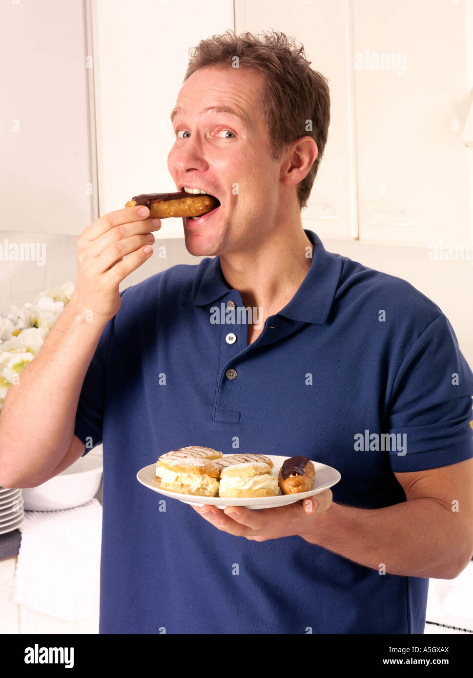 MAN IN KITCHEN EATING CREAM CAKES Stock Photo - Alamy