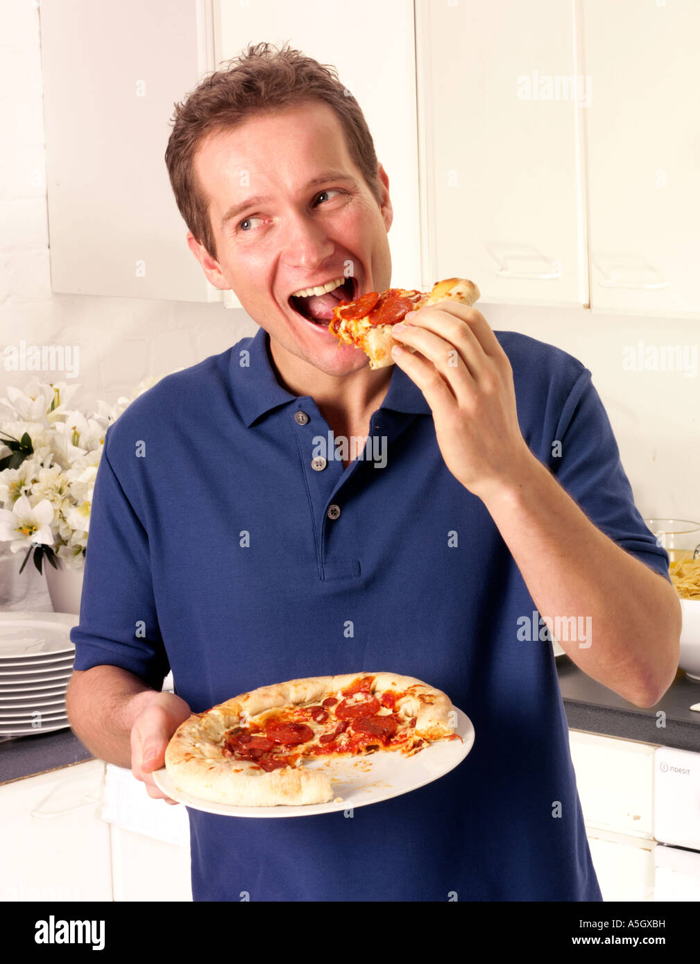 MAN IN KITCHEN EATING PIZZA Stock Photo - Alamy
