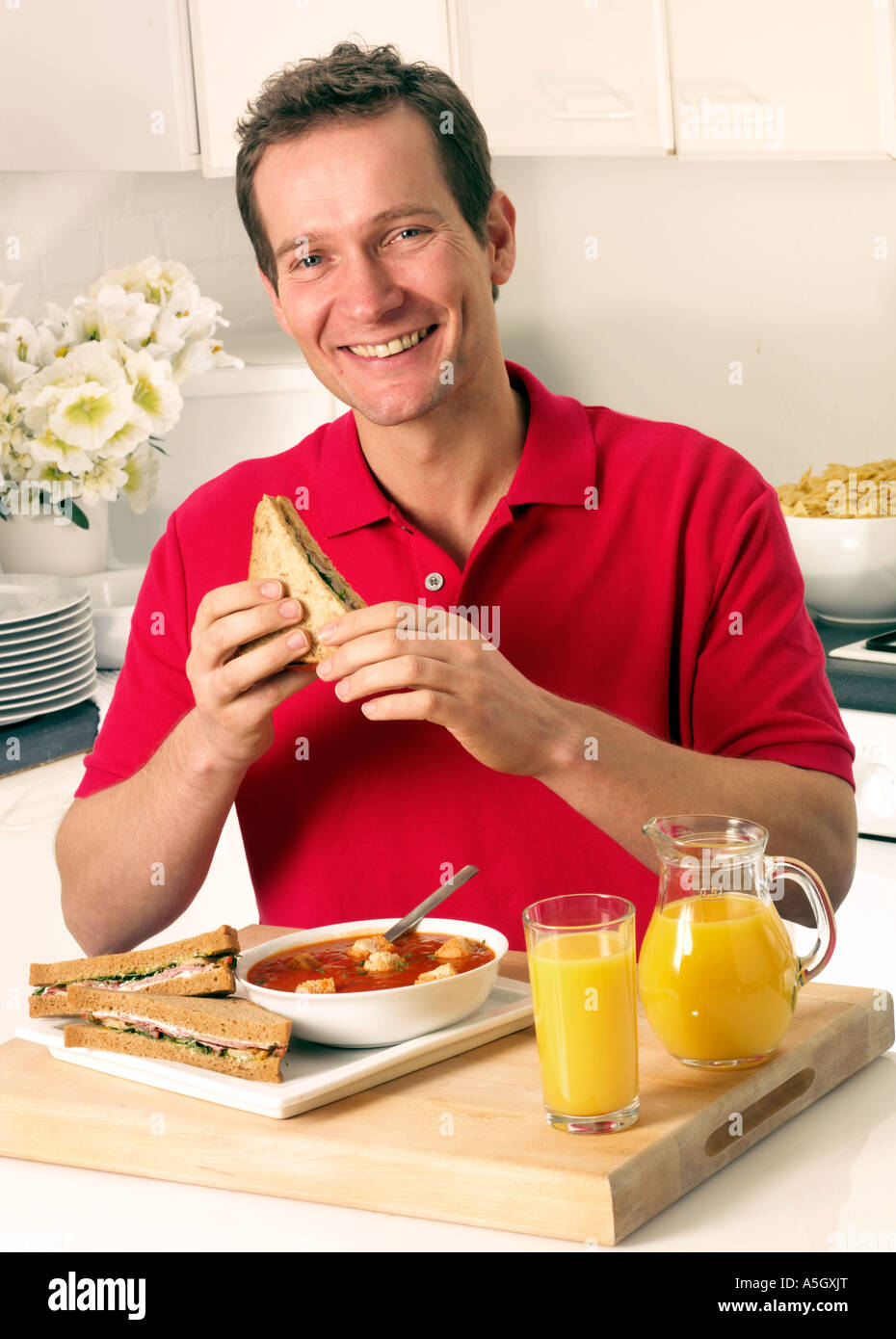MAN IN KITCHEN EATING LUNCH Stock Photo - Alamy