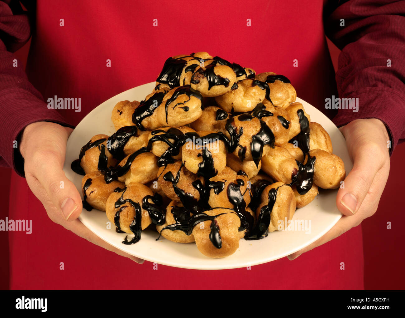 MAN HOLDING PLATE OF PROFITEROLES Stock Photo - Alamy