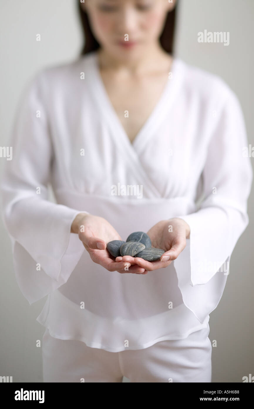 Young woman holding stones Stock Photo - Alamy