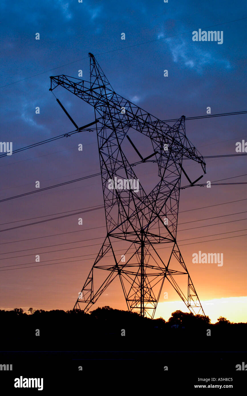 Electric utility tower silhouetted against a bright sunrise Stock Photo ...