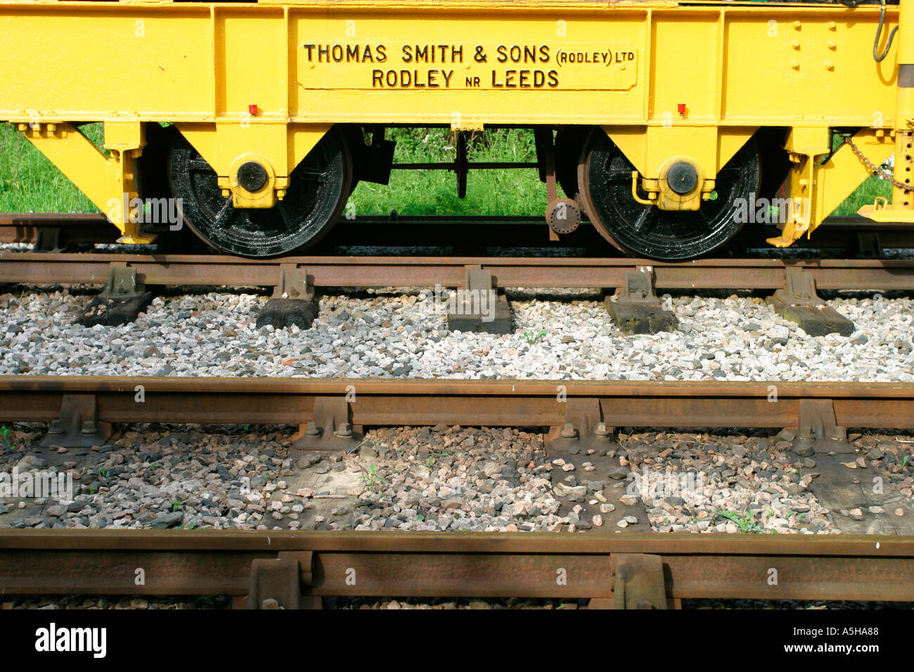 Set of axles and brightly painted yellow truck on rusty rails Stock ...