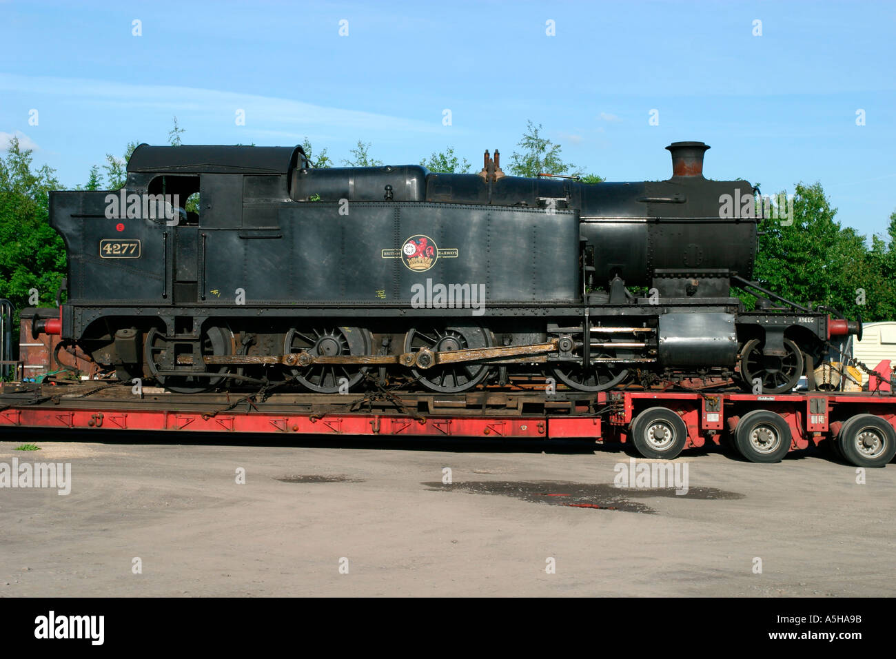 Large steam engine being delivered and unloaded from the back of a ...