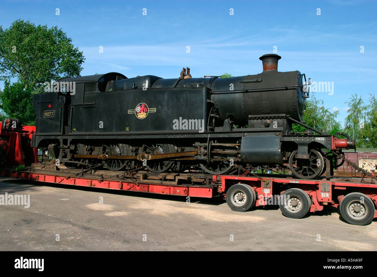 Large steam engine being delivered and unloaded from the back of a ...