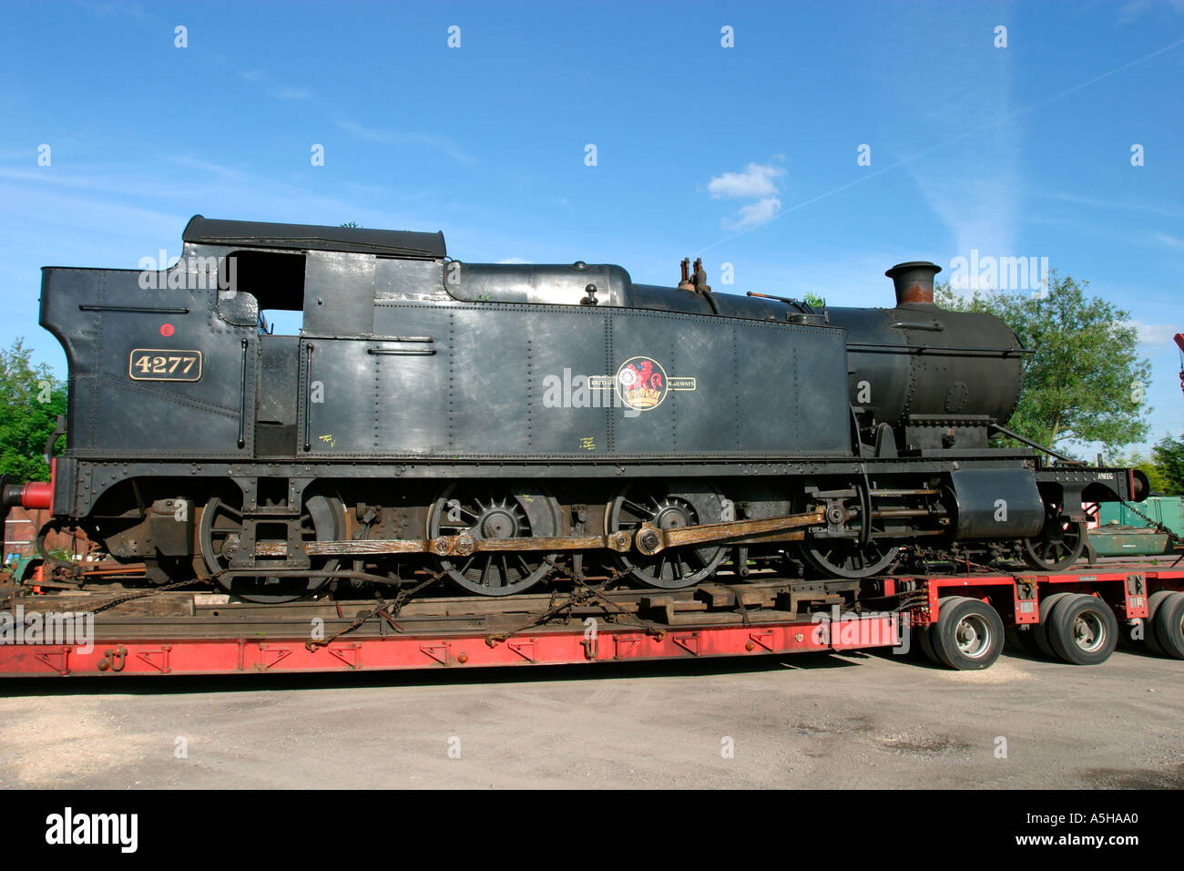 Large steam engine being delivered and unloaded from the back of a ...