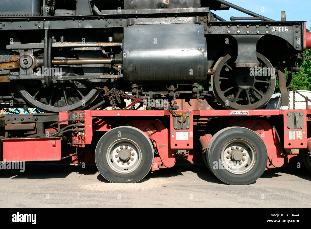 Large steam engine being delivered and unloaded from the back of a ...