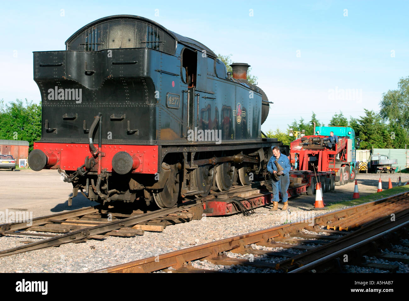 Large steam engine being delivered and unloaded from the back of a ...