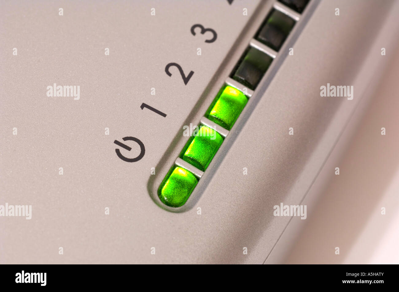 Closeup of a silver-colored ethernet hub with green LED indicators ...