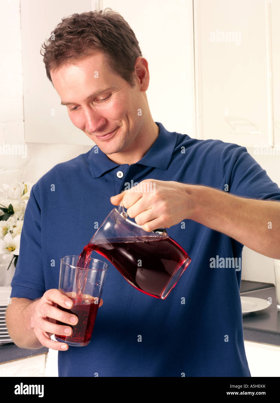 MAN IN KITCHEN WITH CRANBERRY JUICE Stock Photo - Alamy