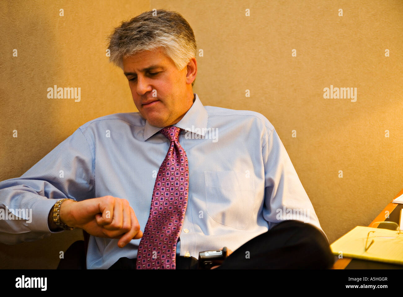 TEXAS Austin Male executive check watch while working at desk in hotel ...