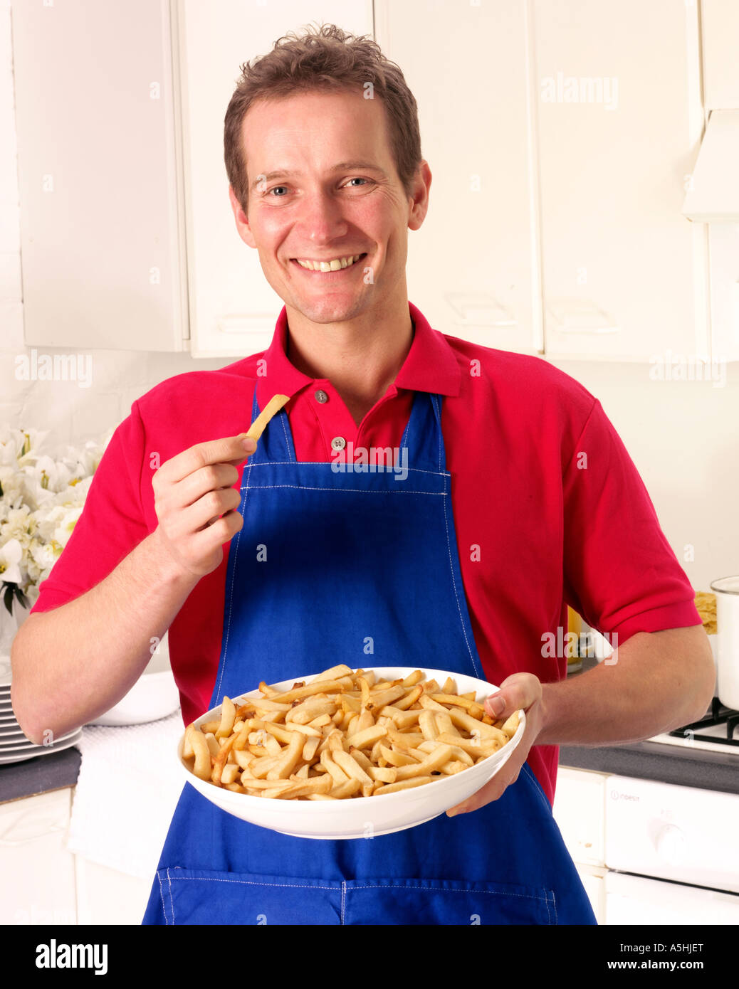 MAN IN KITCHEN EATING CHIPS Stock Photo - Alamy