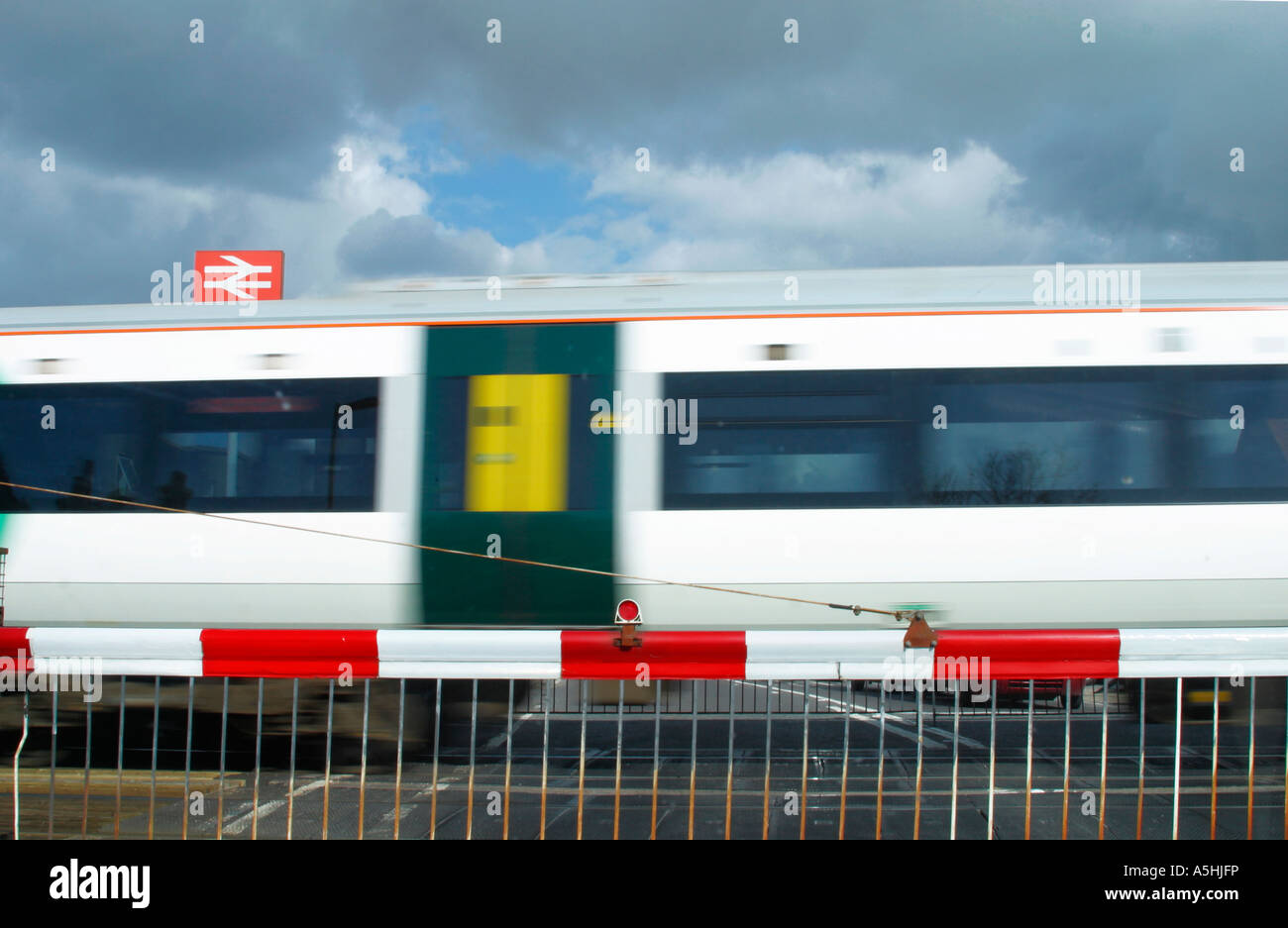 Train speeding through at Ford Station Level Crossing in Sussex, UK ...